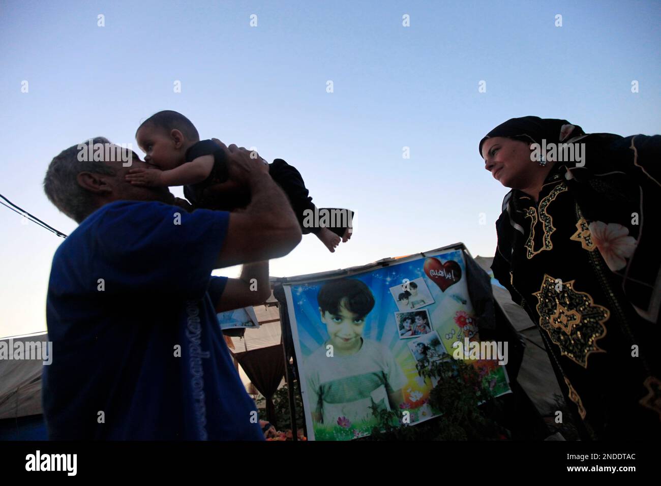 Palestinian Kamal Awaja, 49, left, plays with his five month-old baby ...