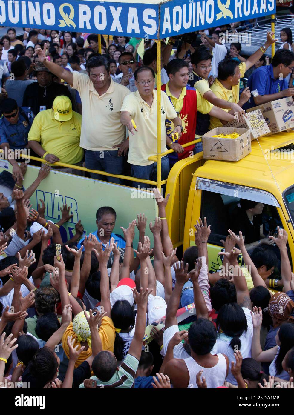 Presidential candidate Sen. Benigno "Noynoy" Aquino III, center, throws ...
