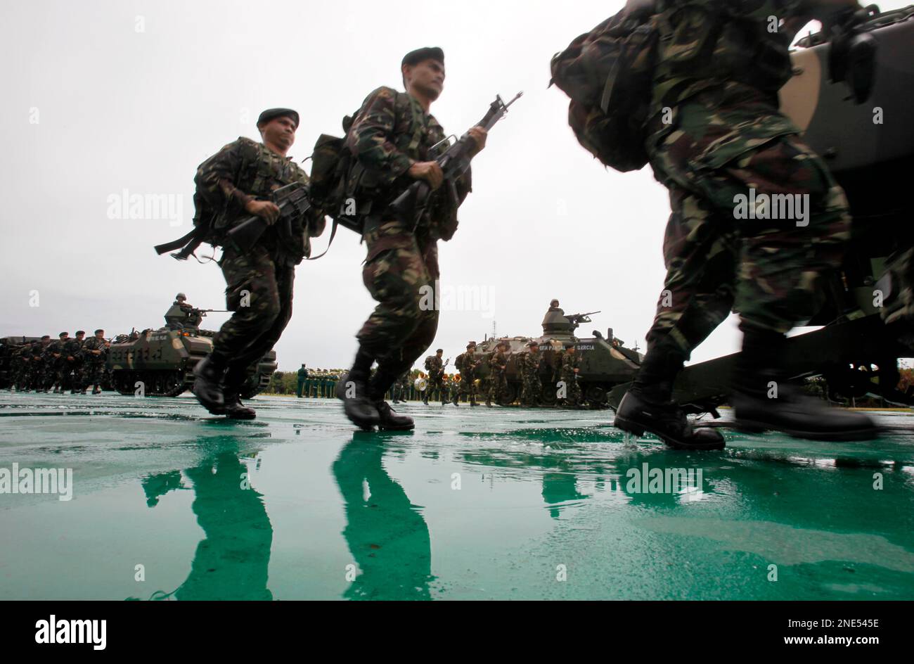 Philippine Army soldiers march with their armored personnel carriers ...
