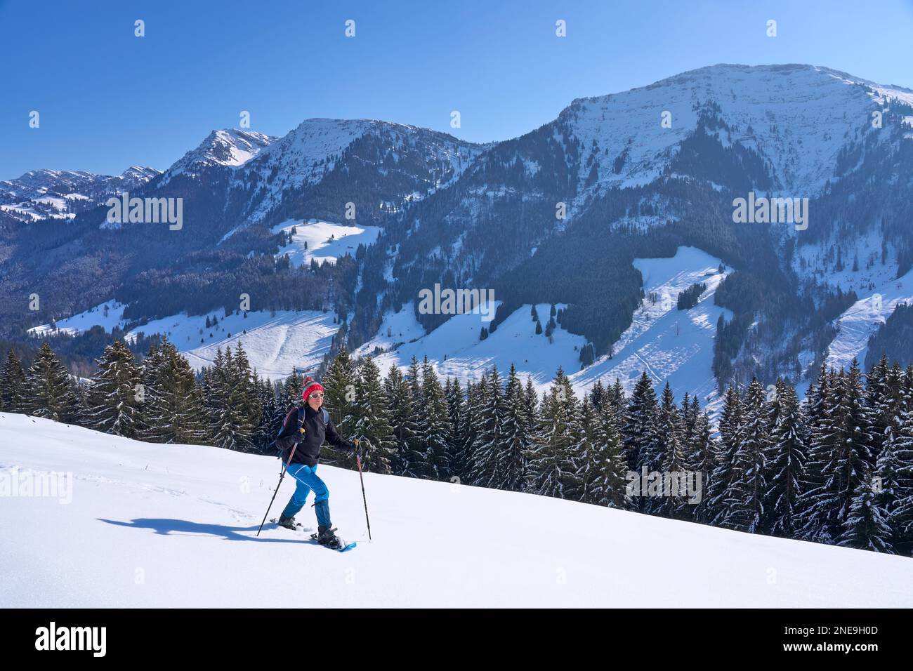 Donna anziana simpatica e attiva che fa racchette da neve in neve ...