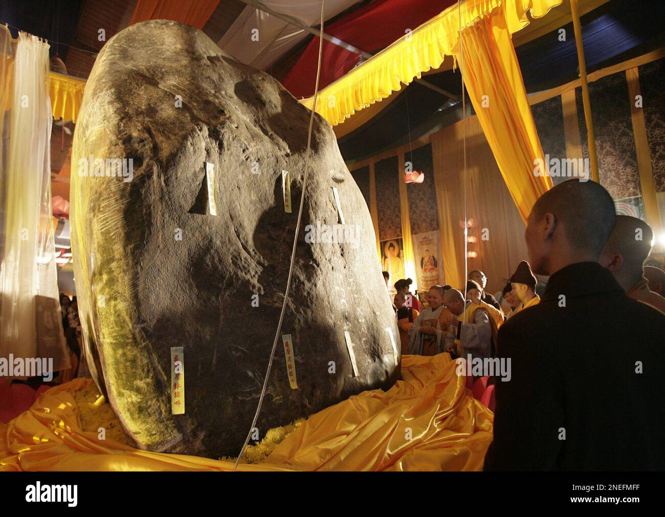 Buddhist monks look a the jade piece as it was unveiled on Monday, Jan ...