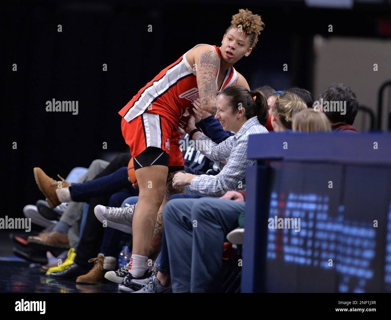Ohio State's Rikki Harris, left, lands in courtside fan seating during ...