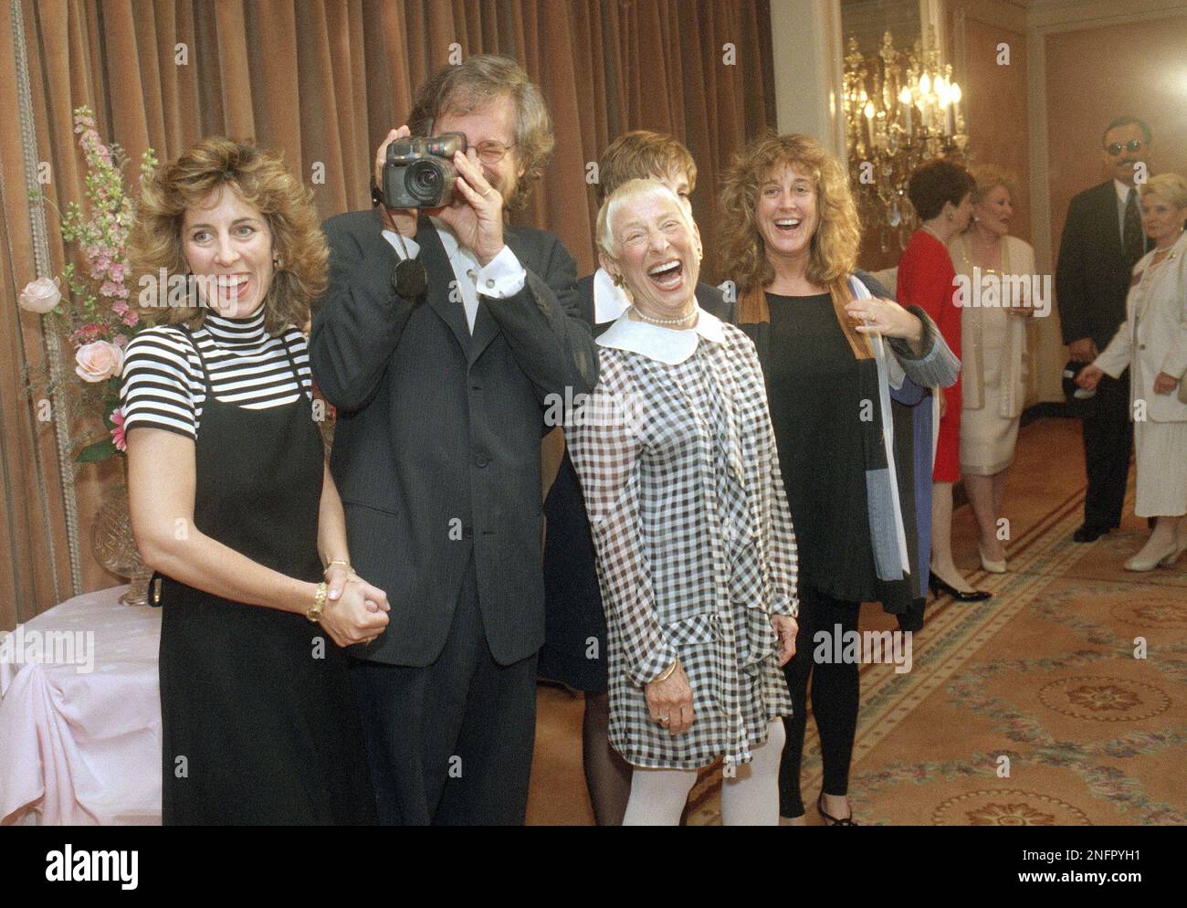 Film director Steven Spielberg films photographers with a home video ...