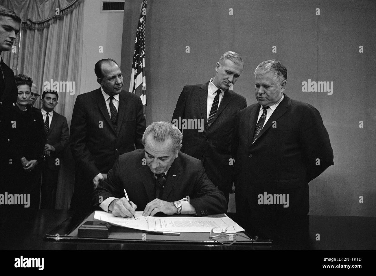 President Lyndon Johnson signs bill at White House signing ceremony in ...
