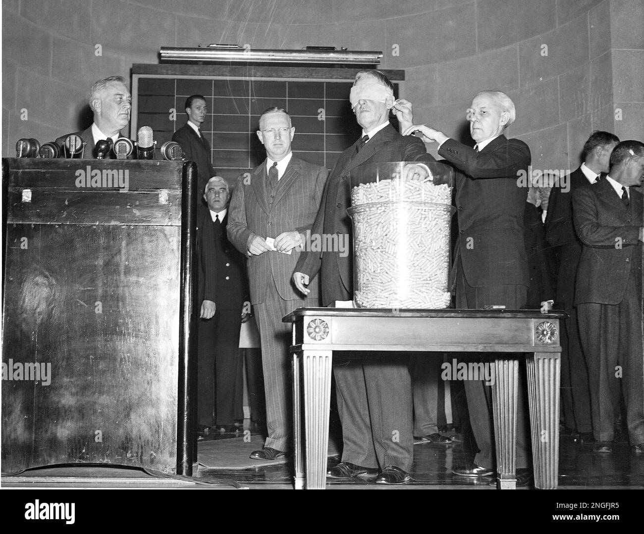 U.S. Secretary of War Henry Stimson is blindfolded as he draws the ...