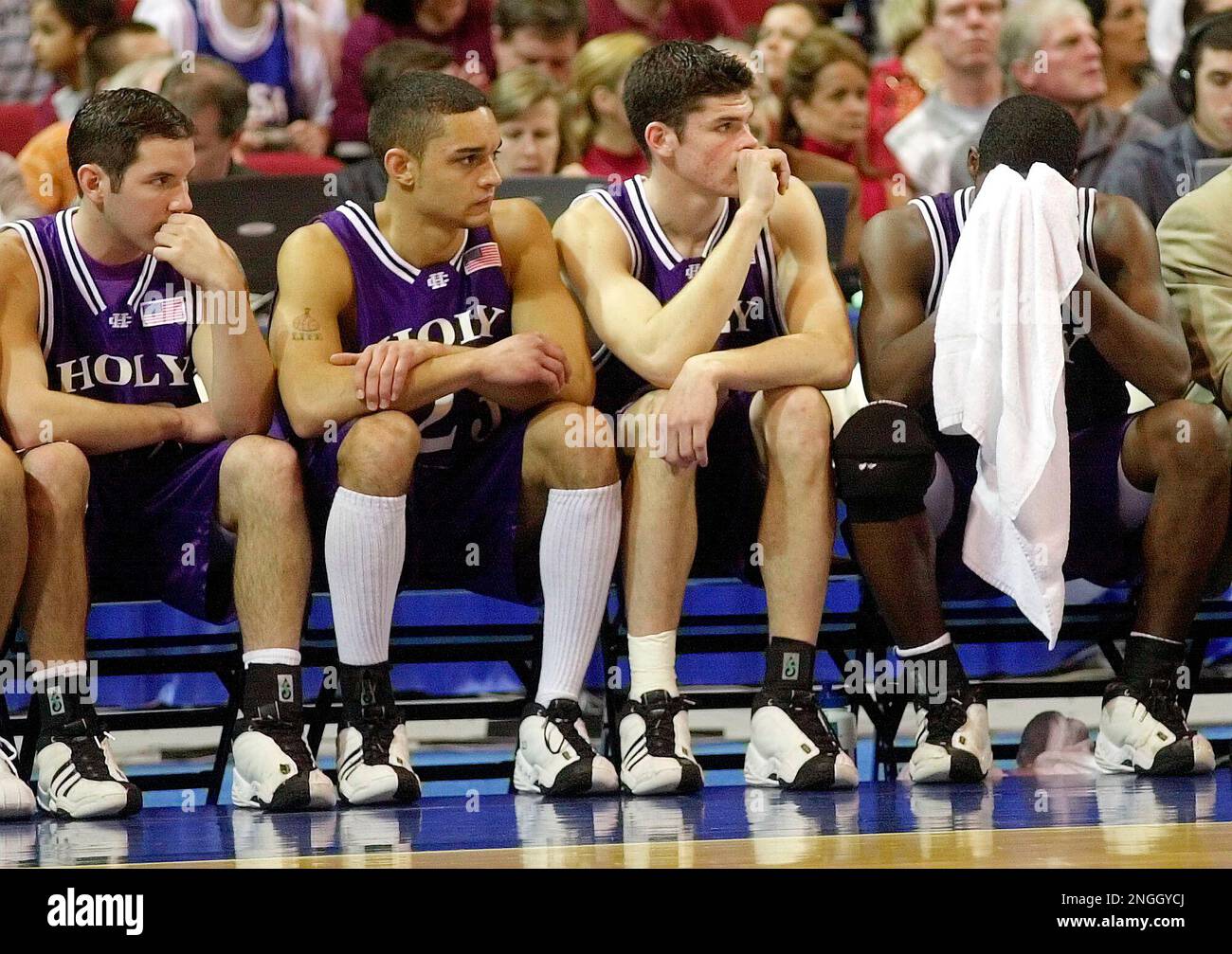 Holy Cross' Brian Wilson covers his face after fouling out, as ...