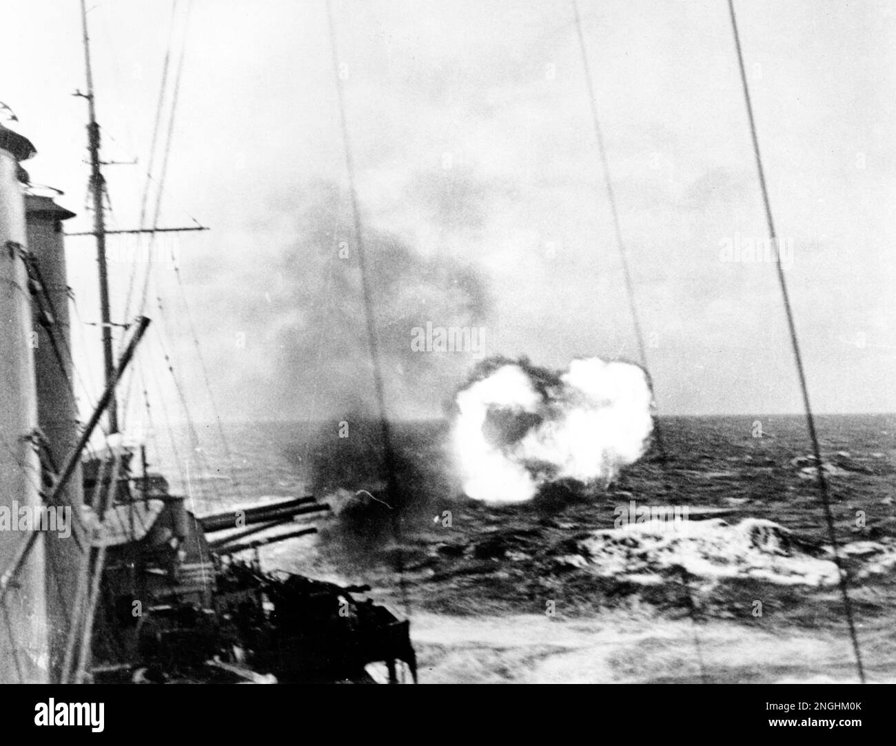 Naval guns of the British Cruiser Norfolk fire at the German Battleship ...