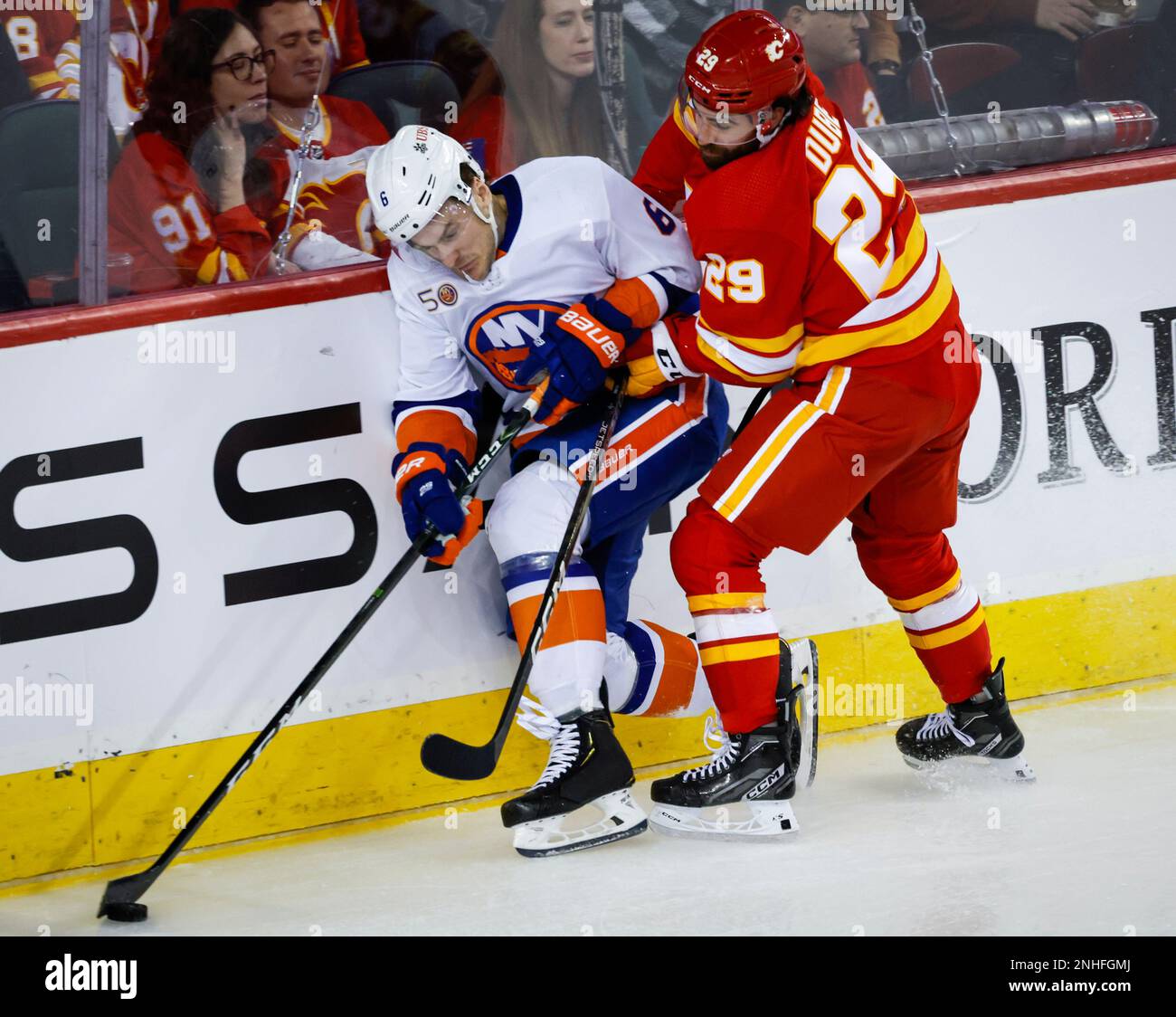 New York Islanders defenseman Ryan Pulock, left, is checked by Calgary ...