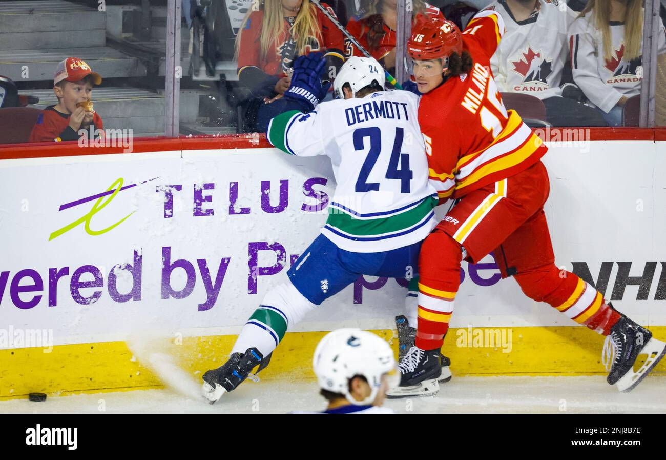 Vancouver Canucks defenseman Travis Dermott, left, checks Calgary ...