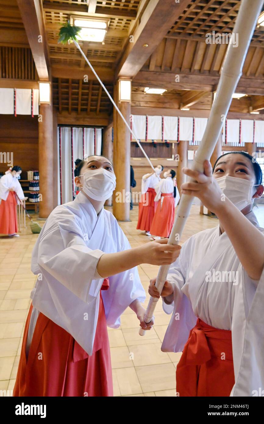 Miko san, Shrine maiden, wearing face masks perform a susuharai by ...
