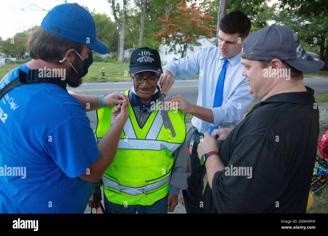 Members of the press attach lavalier microphones to Thomas Faucette, a ...