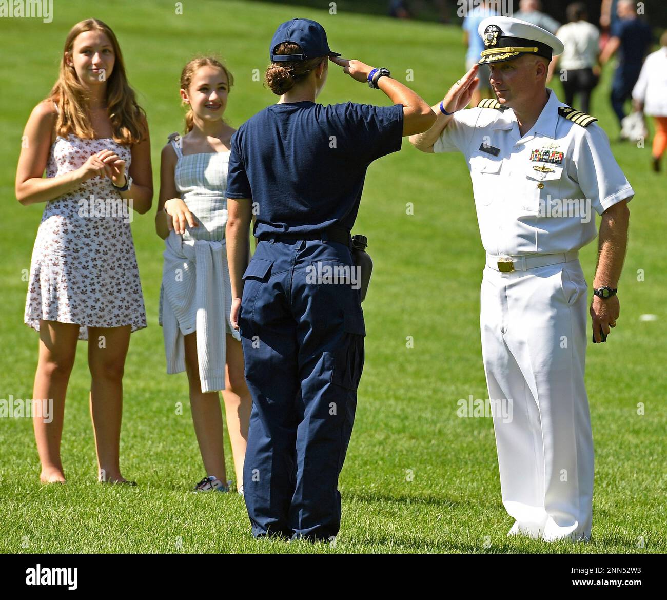 U.S. Navy Capt. Luke Greene, right, salutes his daughter Madelyn, as ...