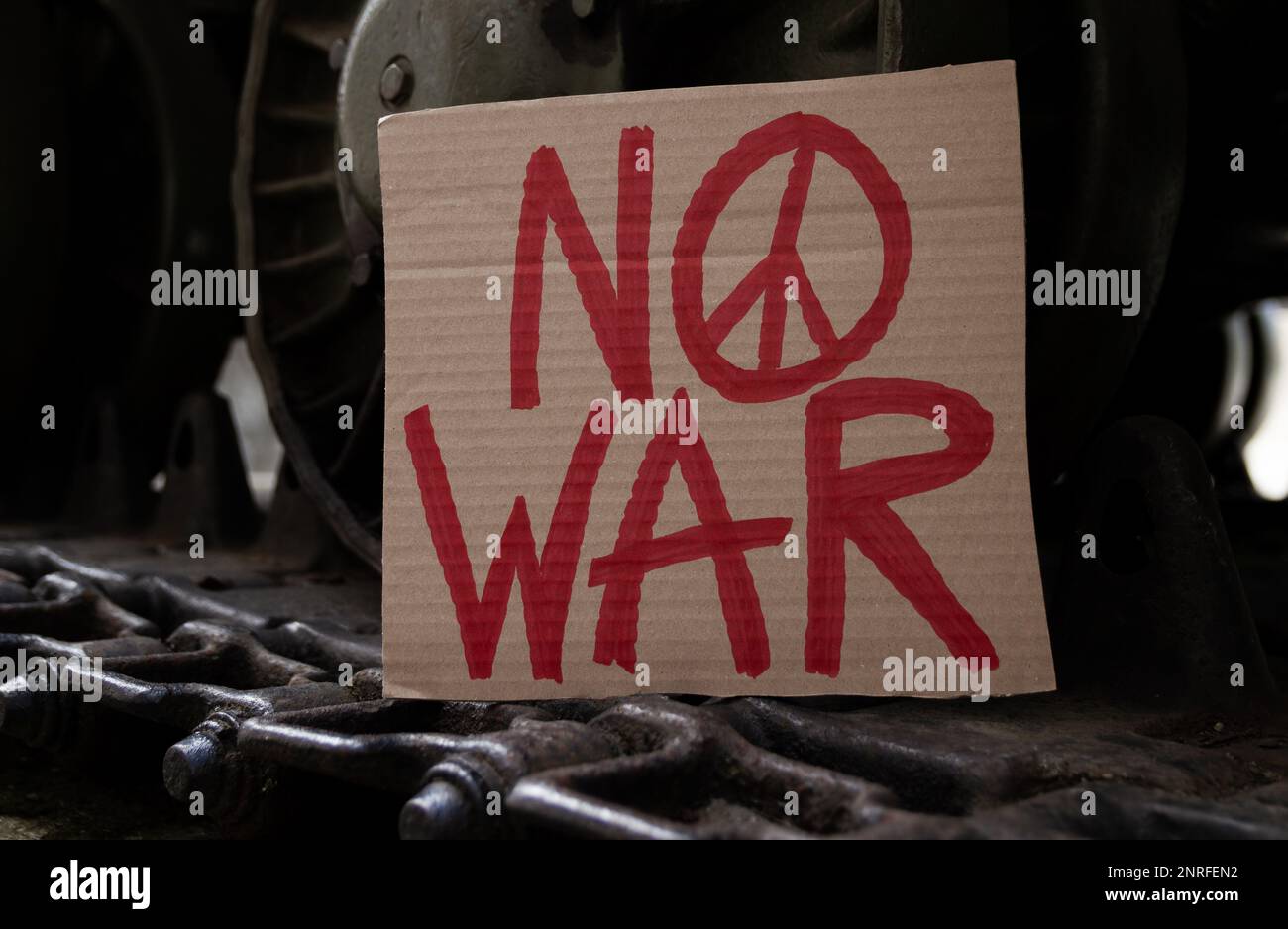 Cartello "No War" con il simbolo di pace sulle ruote cingolate continue ...