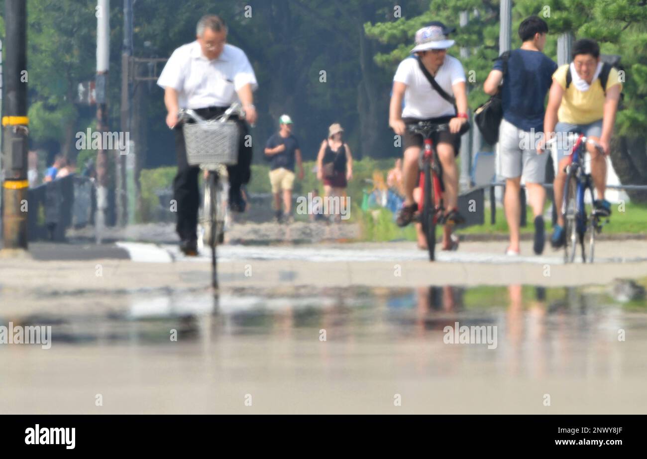Road mirage is observed in hundred-degree weather in Tokyo on July 18 ...