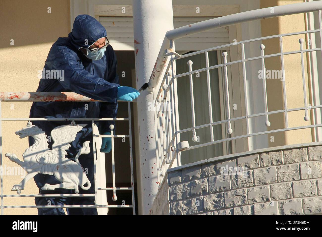 A forensic police officer gathers evidence at an apartment block in ...