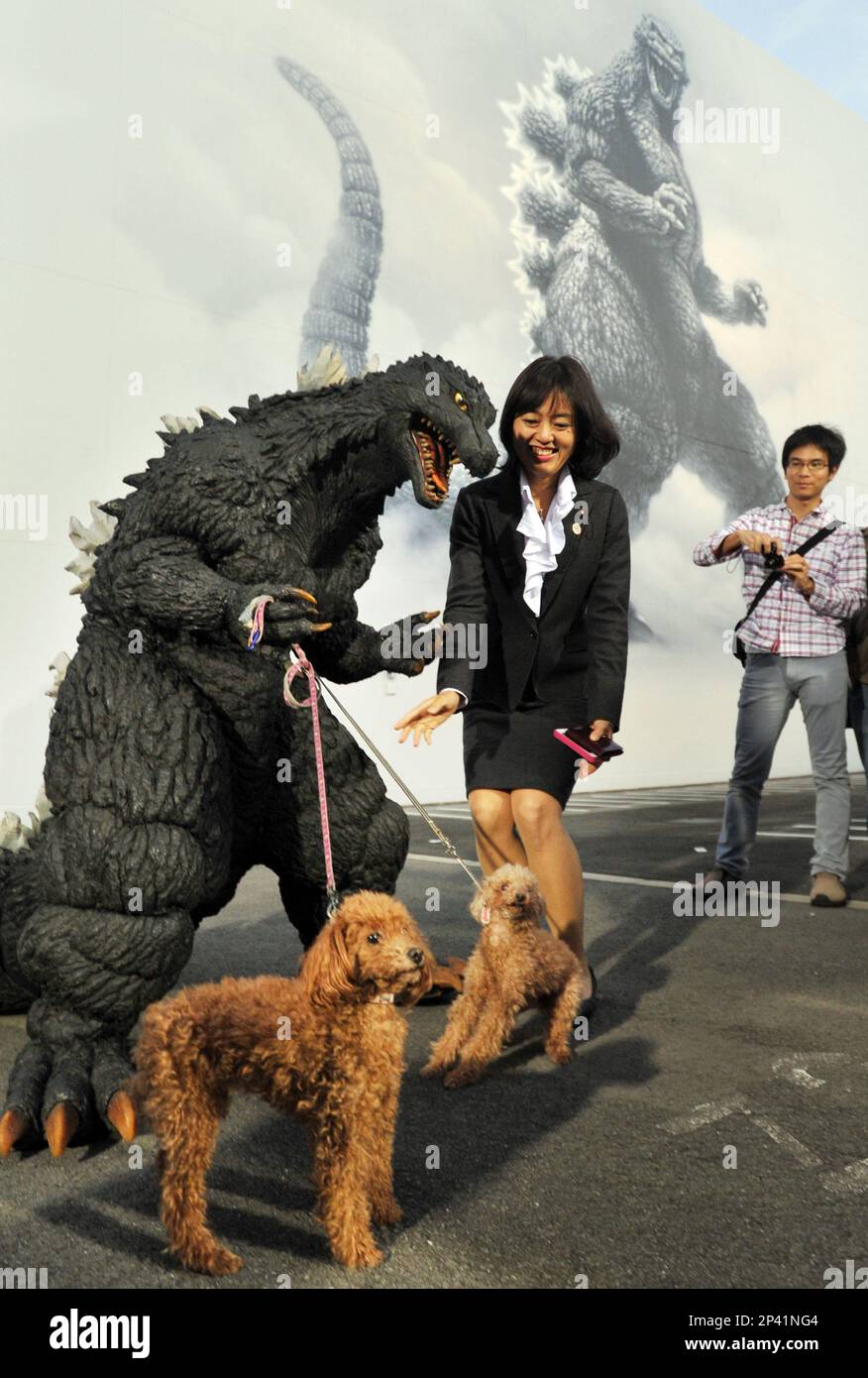 Japan's most popular monster Godzilla (L) poses with a fan taking dogs ...