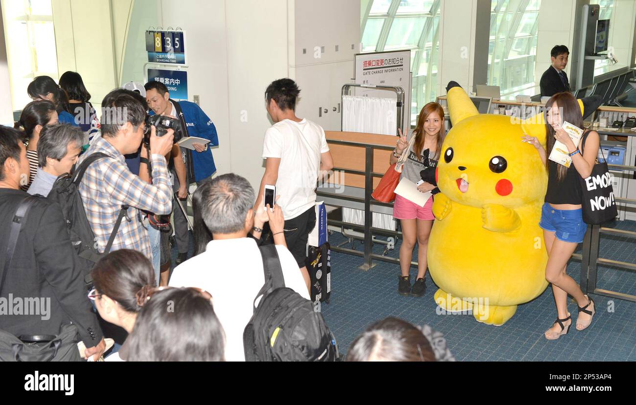Passengers pose with Pikachu, an anime character at the depature gate ...