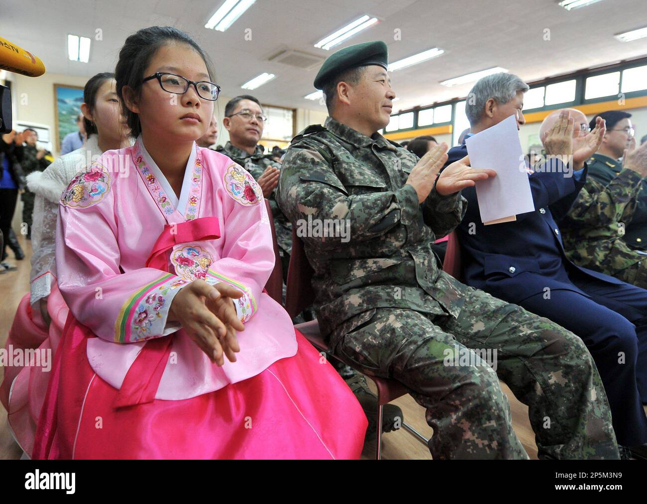 South Korean graduates, left, wearing traditional dress sit next to ...