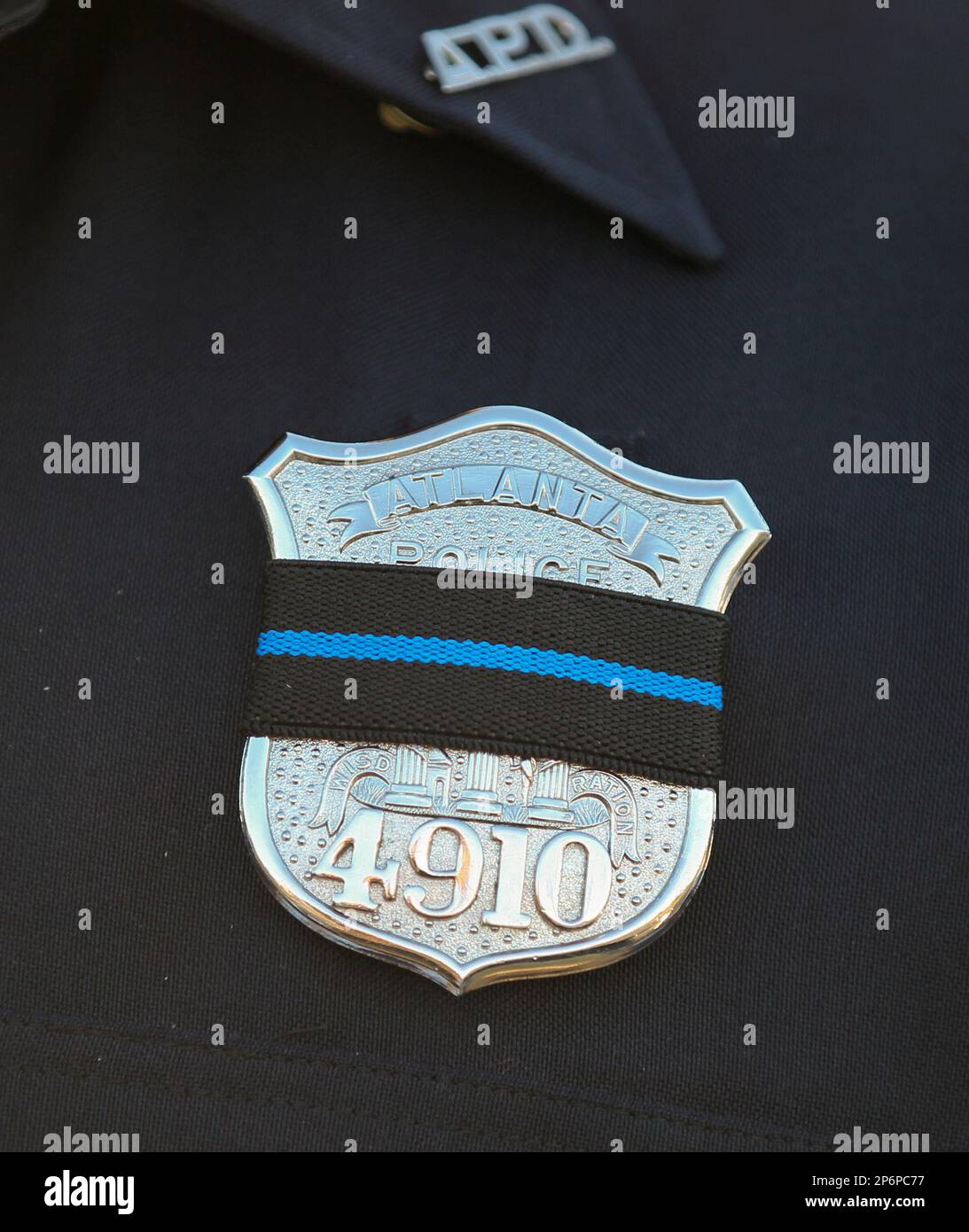 A police badge is pictured as hundreds of police officers, including a ...