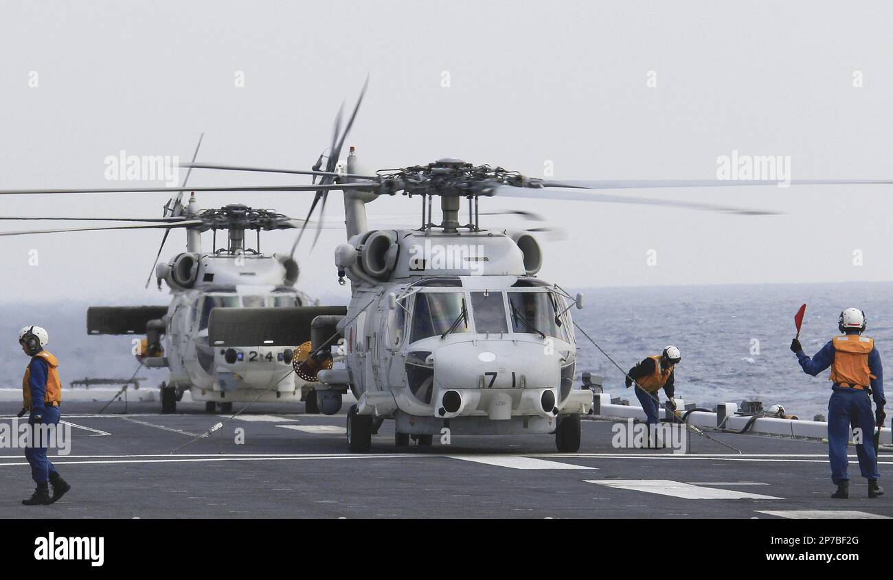 Helicopters are taking off from the deck of the Hyuga, a destroyer ship ...