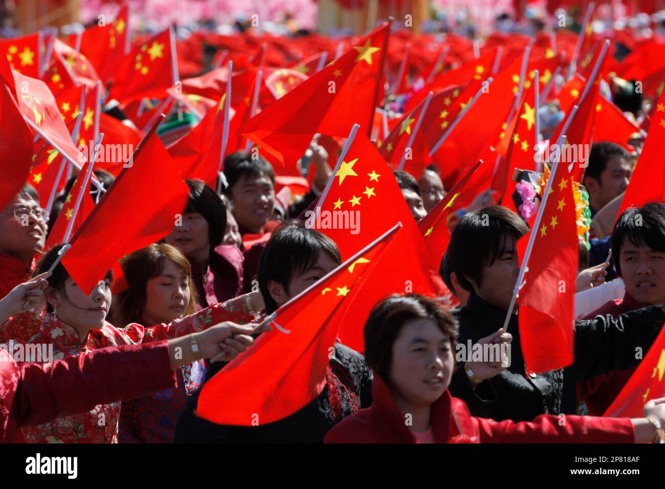 Chinese waves national flags as they march past Tiananmen Square during ...