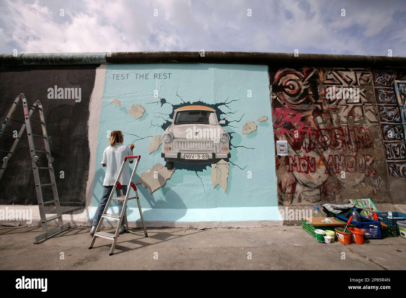 German artist Birgit Kinder paints her picture "Trabi" at the East Side ...