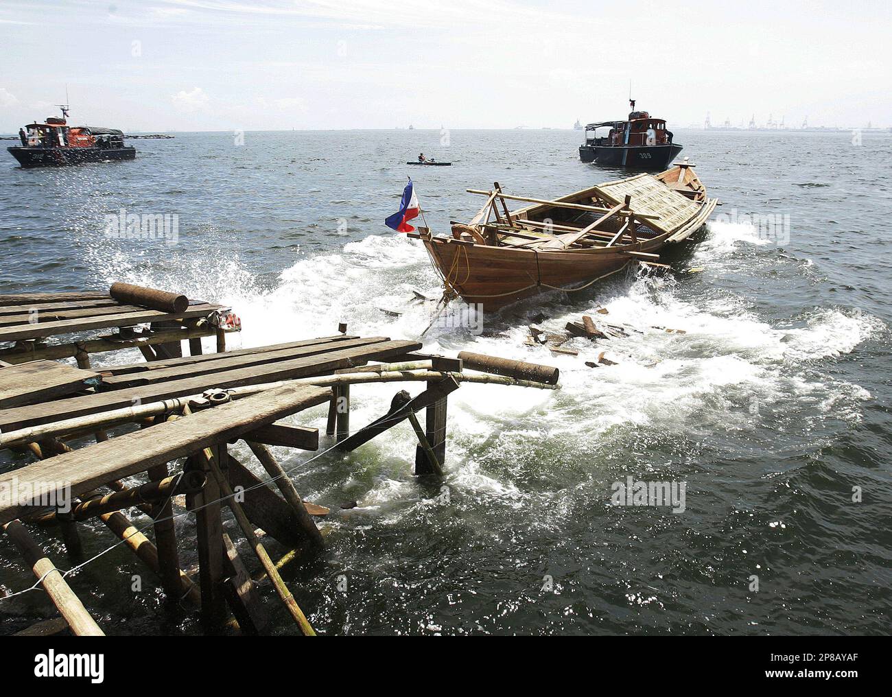 A replica of the Balangay, center, a wooden-hulled boat used around the ...