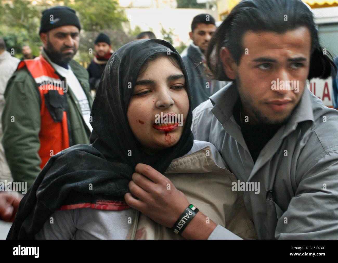 A Palestinian assists a wounded woman, who according to Palestinian ...