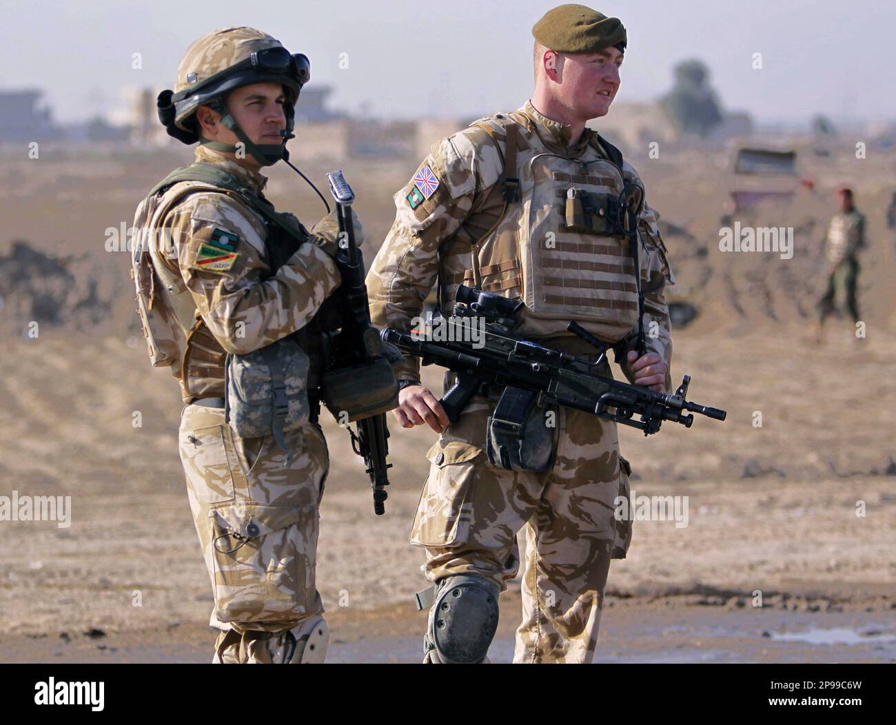 British soldiers, stand guard as Iraqi soldiers celebrate Iraqi Army ...