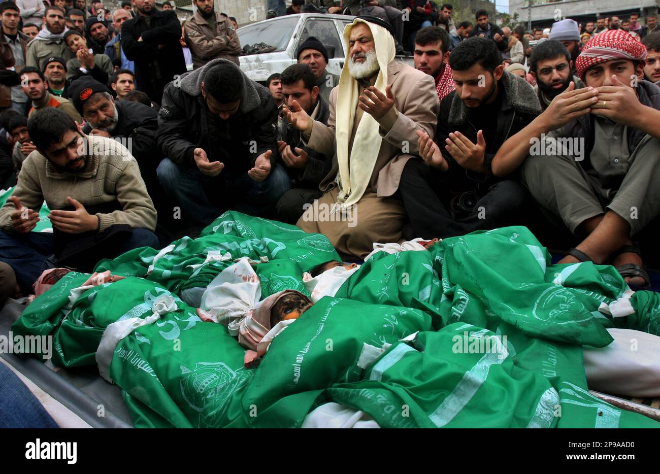 Palestinians pray next to the bodies of family members of Hamas leader ...