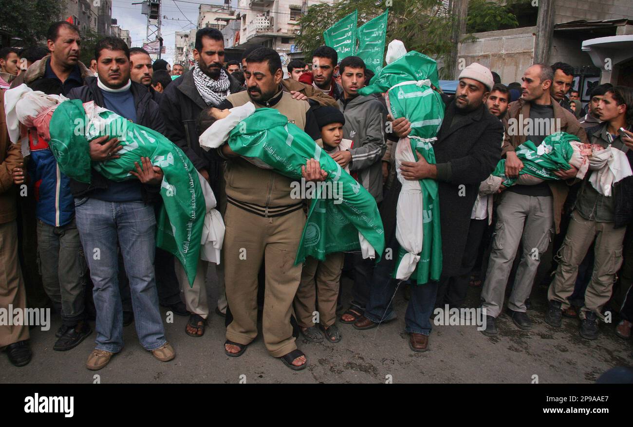 Palestinians carry the bodies of family members of Hamas leader Nizar ...