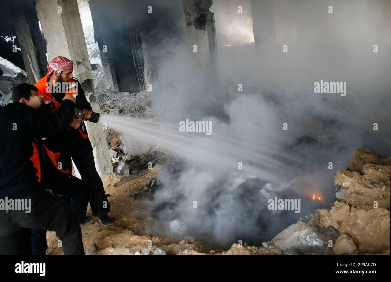 Palestinian firefighters try to extinguish a fire at a building used by ...