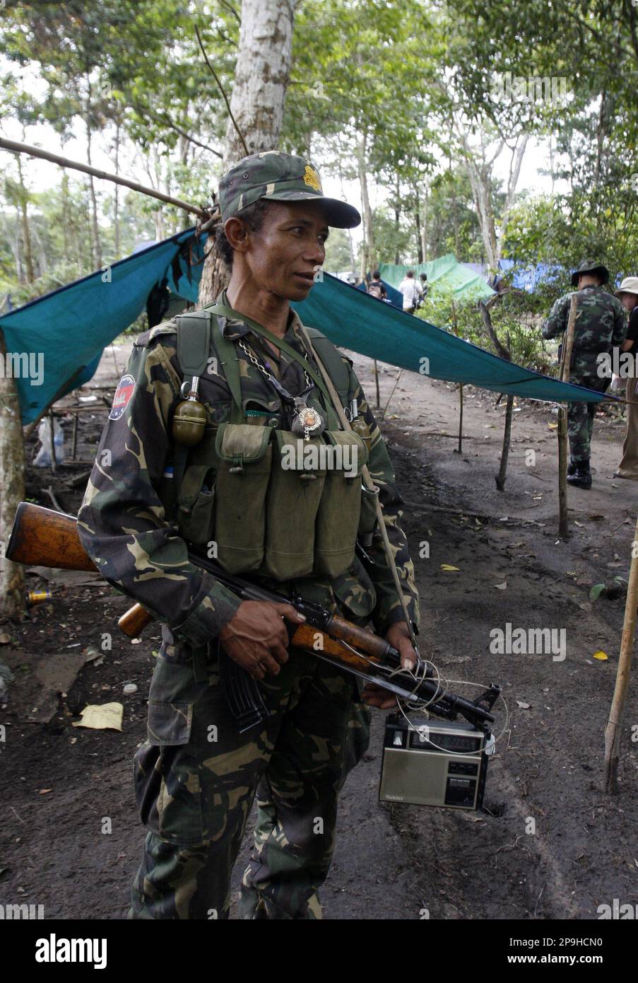 A Cambodian soldier listens to the radio on the frontline near the ...