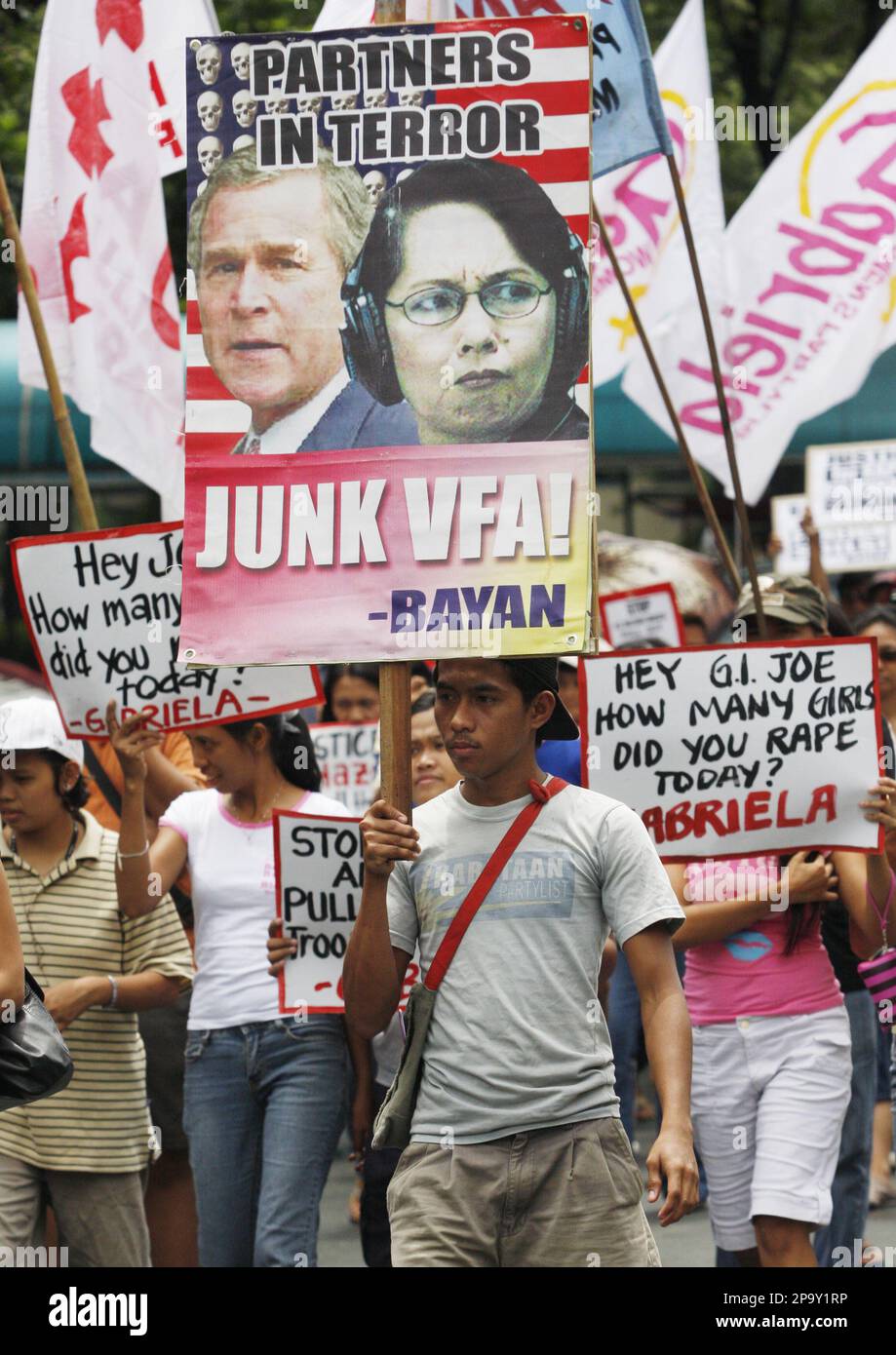 Activists hold slogans as they march towards the U.S. embassy in Manila ...