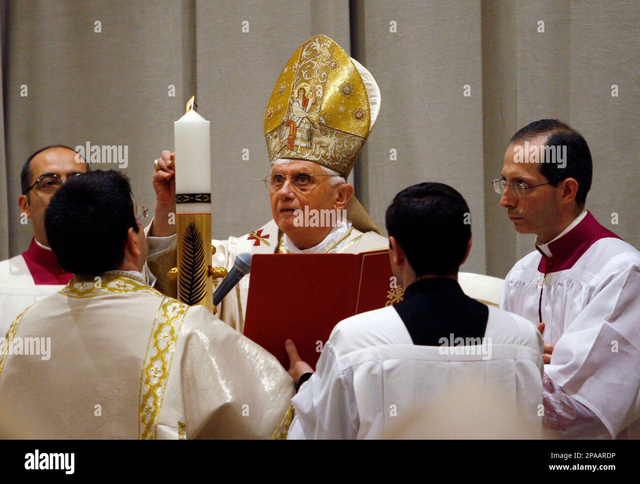 Pope Benedict XVI lights a candle during the Easter vigil mass in St ...