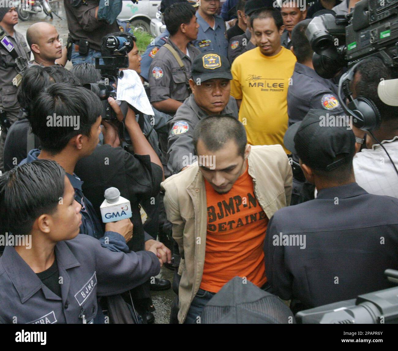 Handcuffed members of the extremist Abu Sayyaf Group, in yellow and ...