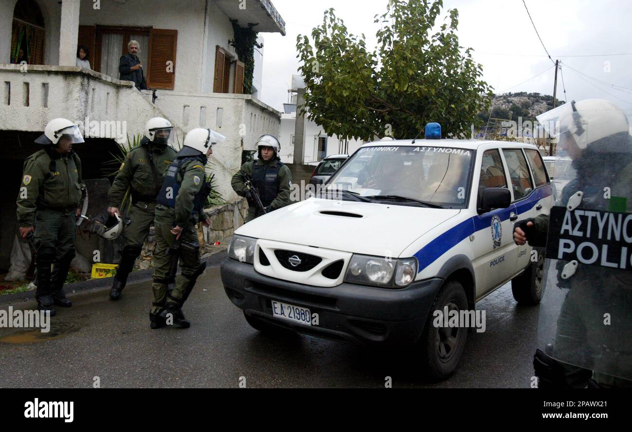 Police units start a raid as residents from a house look on at Zoniana ...