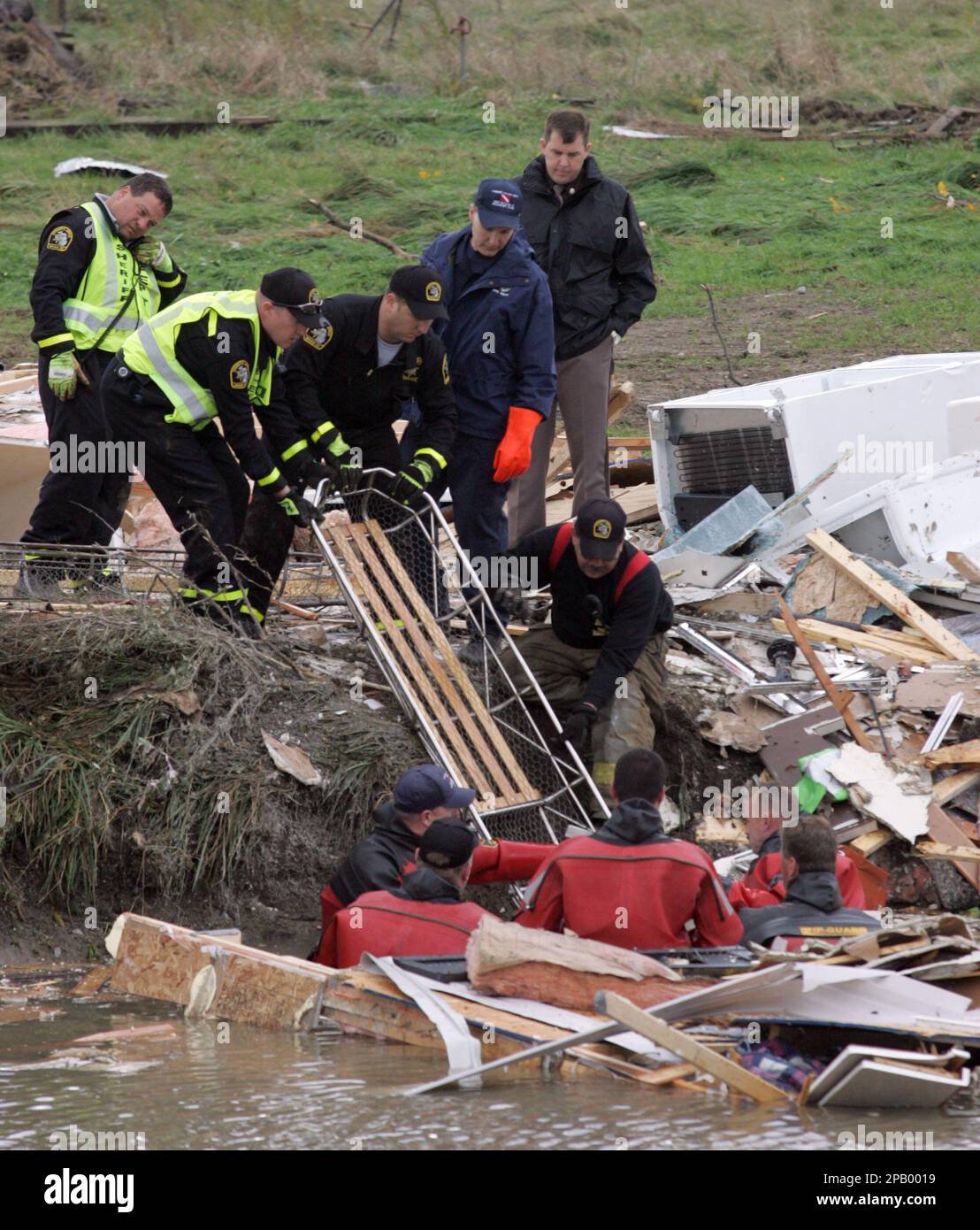 Rescue workers prepare to remove the body of one of two people from ...