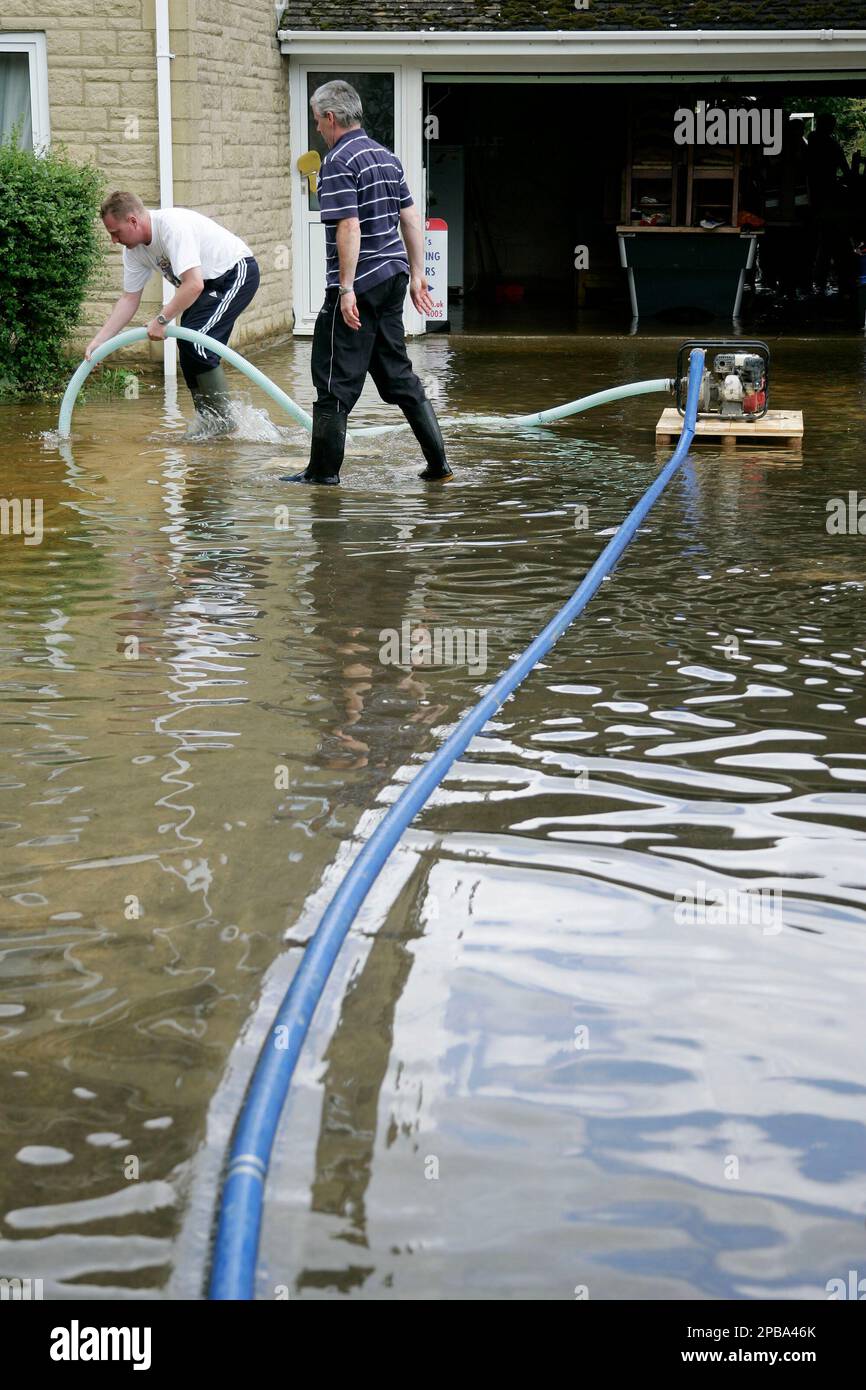 Residents attempt to pump out flood water from their house in Standlake ...