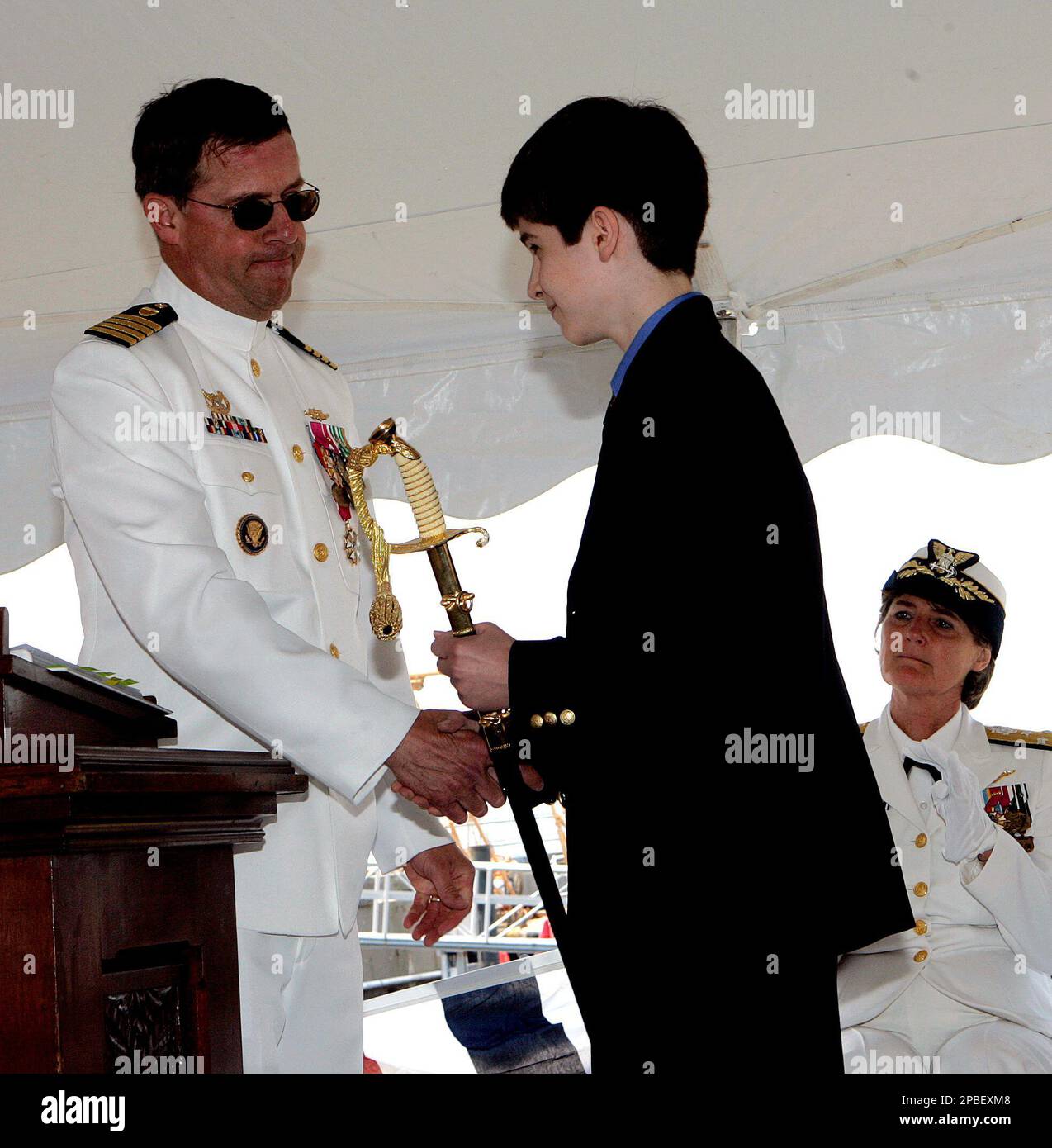 U.S. Coast Guard Capt. Peter J. Boynton turns his officer's sword over ...