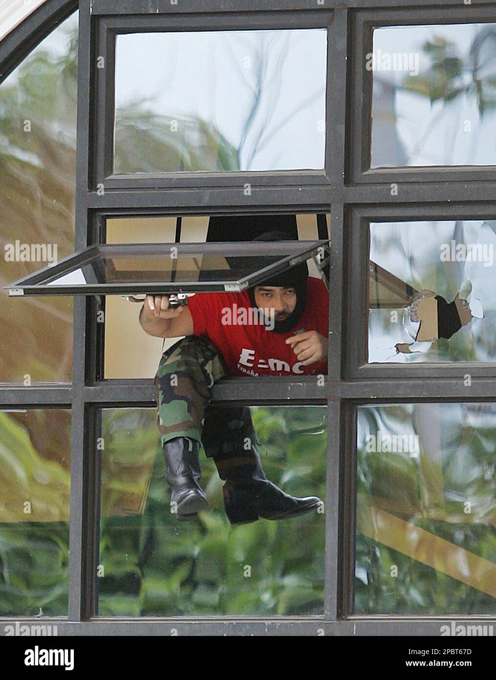 Al Bautista, who also uses the alias Almario Villegas, holds a gun and ...