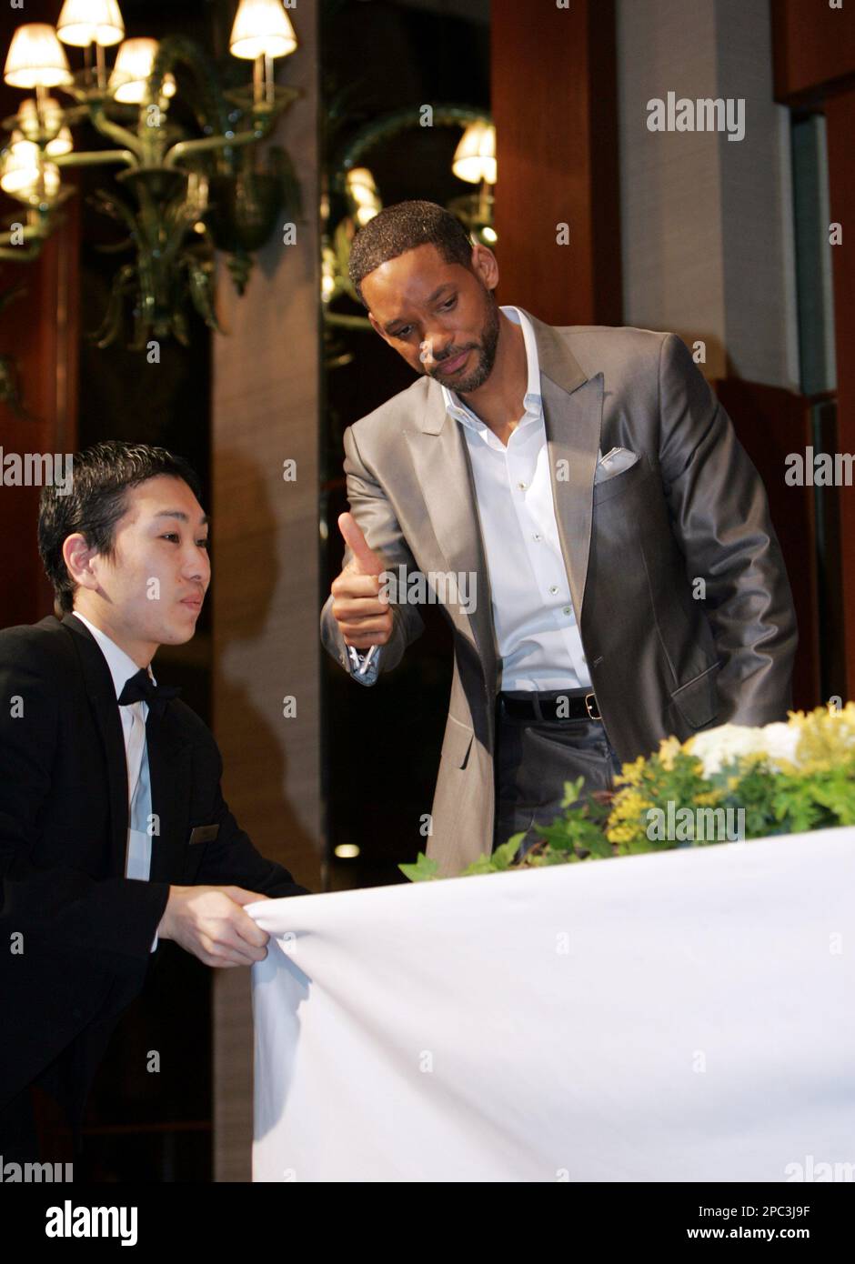 U.S. actor Will Smith gives a thumbs-up as he helps hotel staff ...