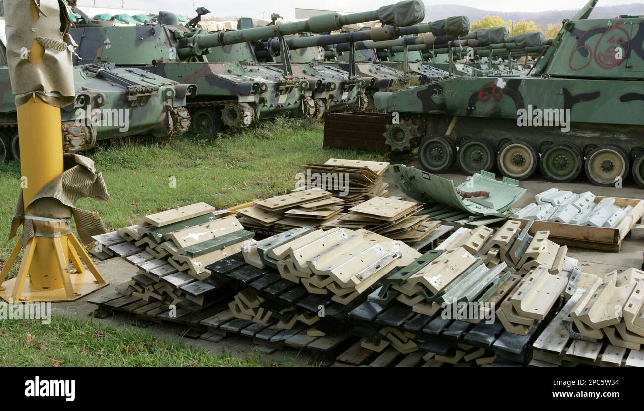 *Piles of treads are stacked on pallets around old military equipment ...