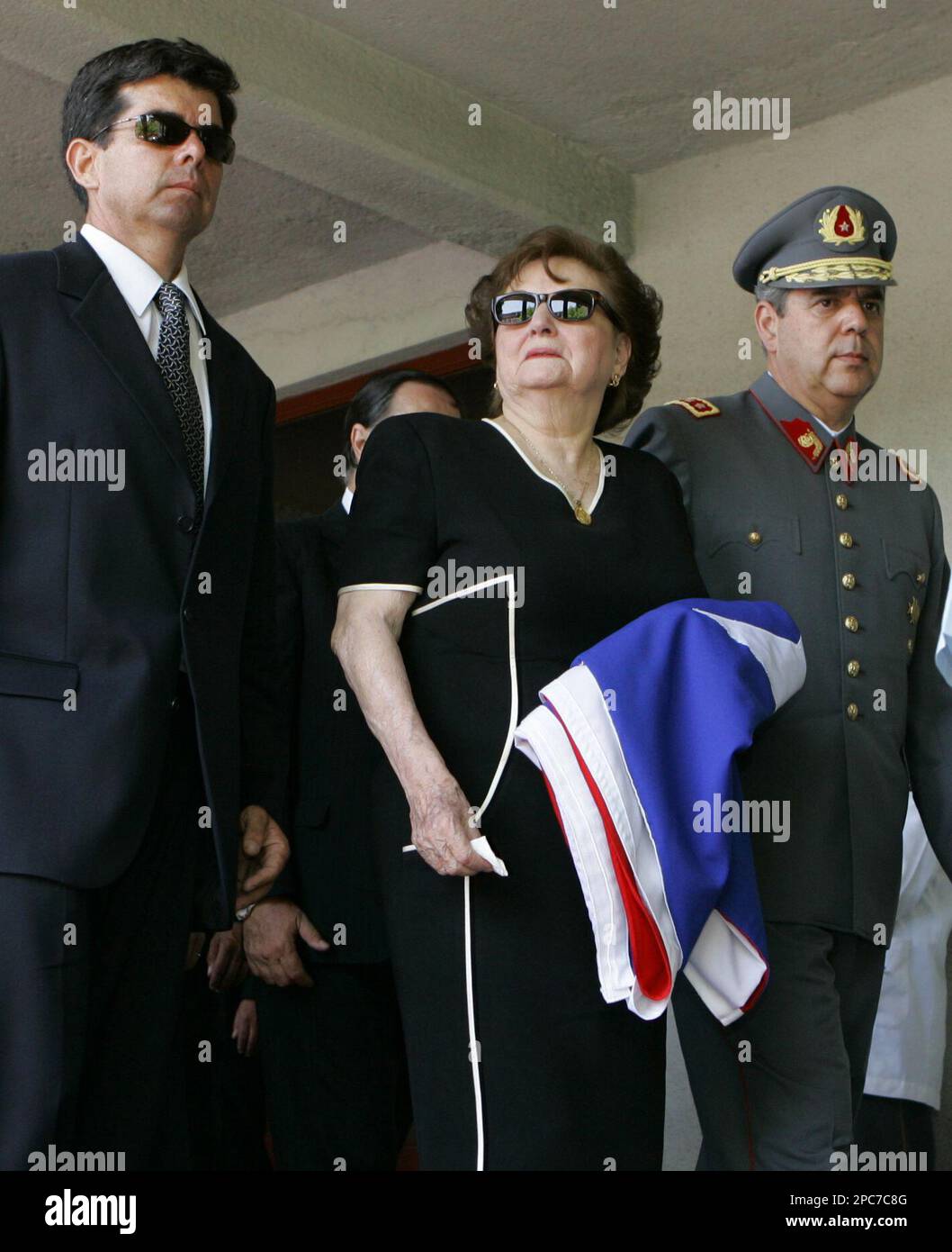 Lucia Hiriart de Pinochet carries the flag that covered the casket of ...