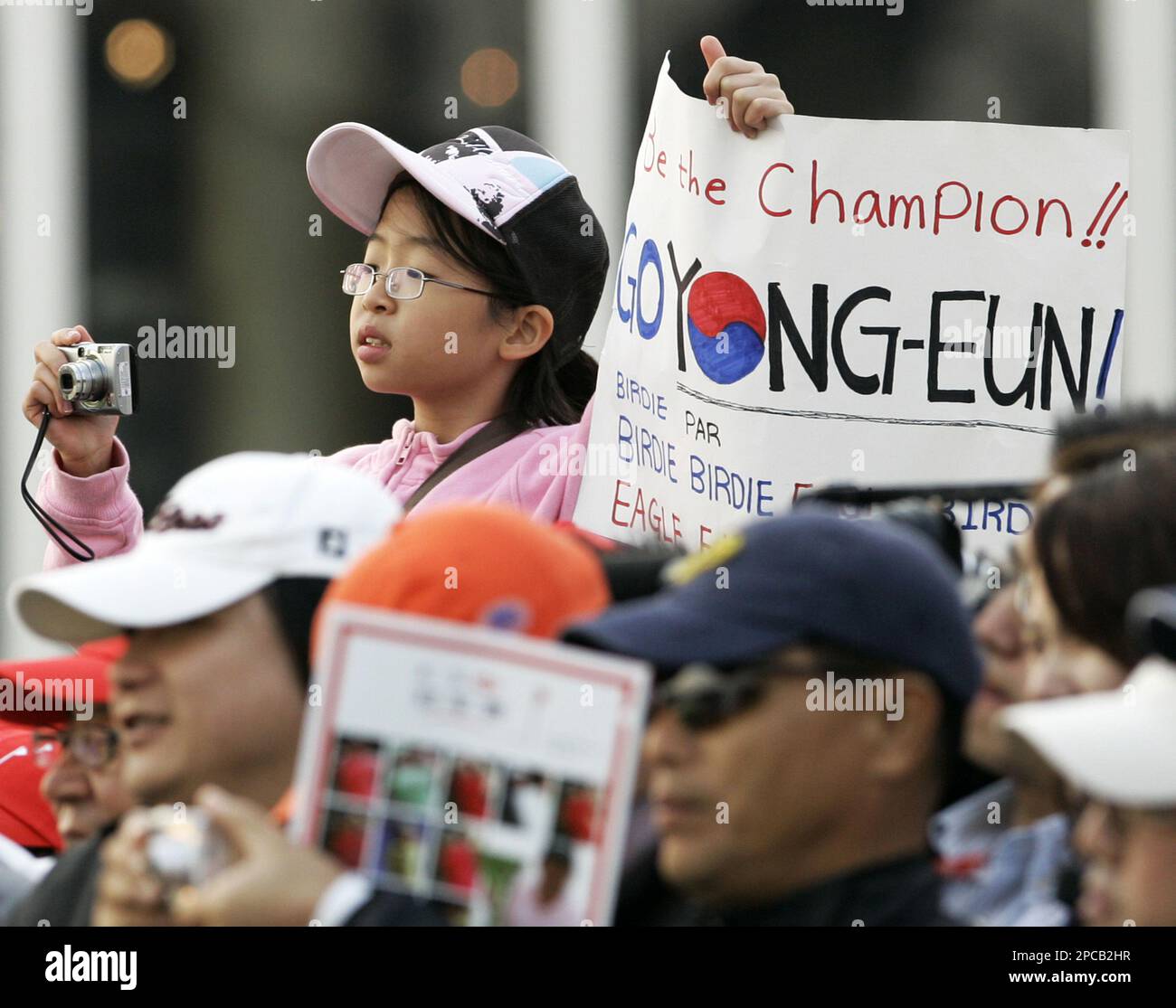 A young fan of South Korean golfer Yang Yong-eun takes picture of Yang ...