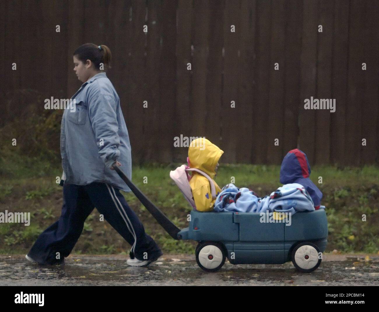 Maria pulls a wagon with her children, 5-year-old Kira, center, and 3 ...