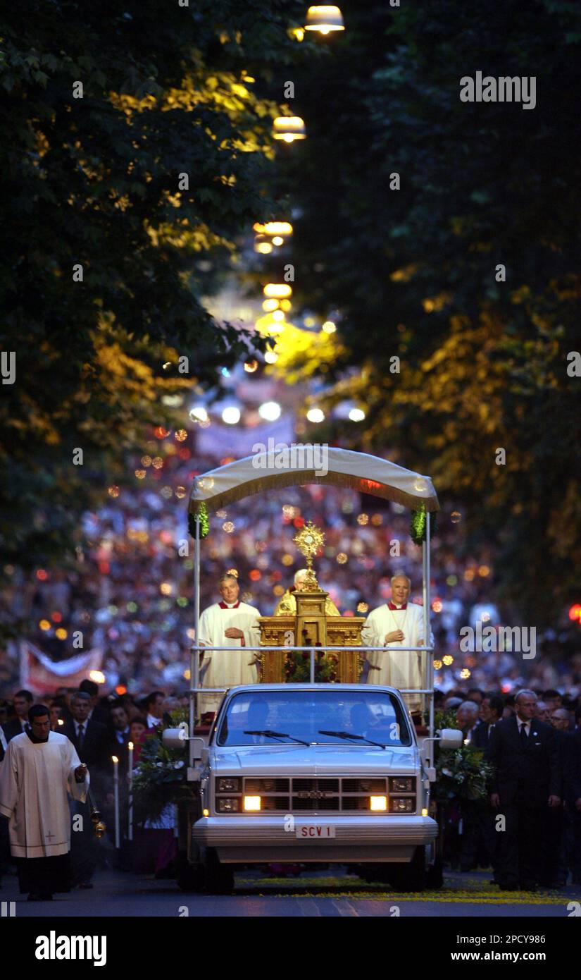 Pope Benedict XVI followed by the faithful, leads the Corpus Christi ...