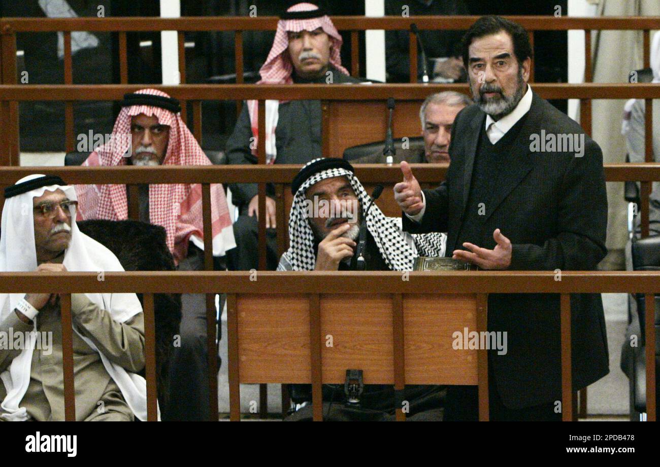 Former Iraqi President Saddam Hussein, right, speaks at his trial in ...
