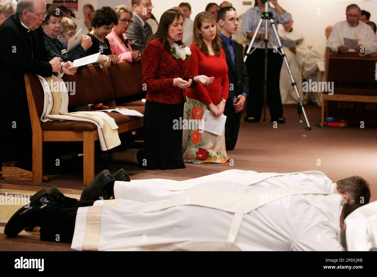 Father Gregory Elder, rear, and Father Mark Bertelli, foreground, lie on the floor as they are ...