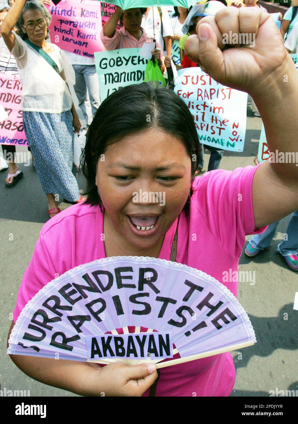 An angry female protester clenches her fist to show her emotion during ...